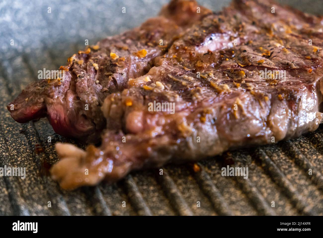 Viande de bœuf juteuse steak cuisson sur une poêle à grill dans une ...