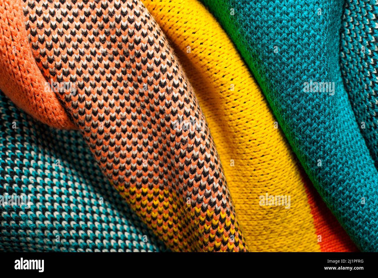 Une pile de tissus synthétiques tricotés multicolores de différentes ...