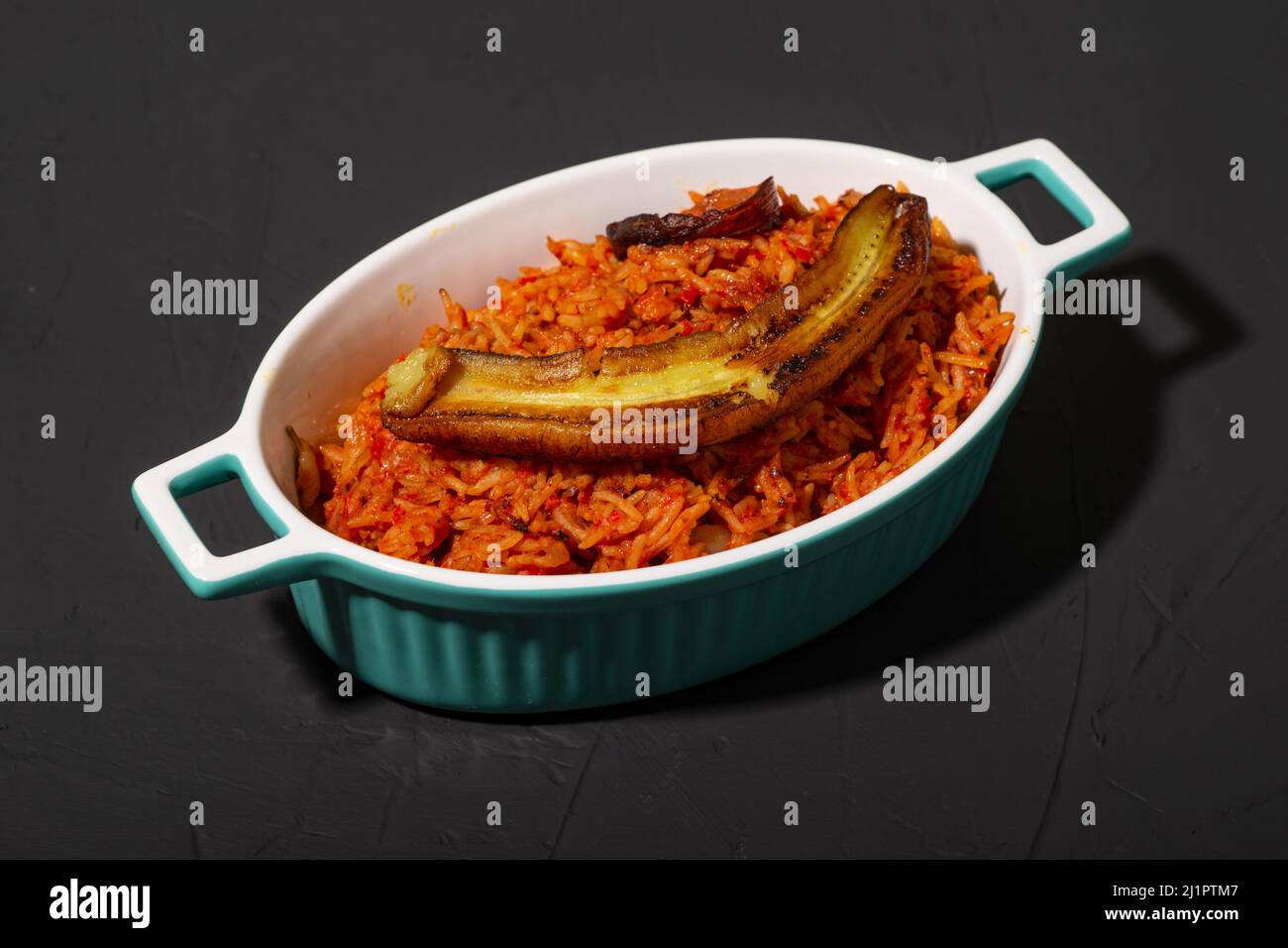 Riz Jollof avec banane frite. Riz nigérian traditionnel avec tomates ...