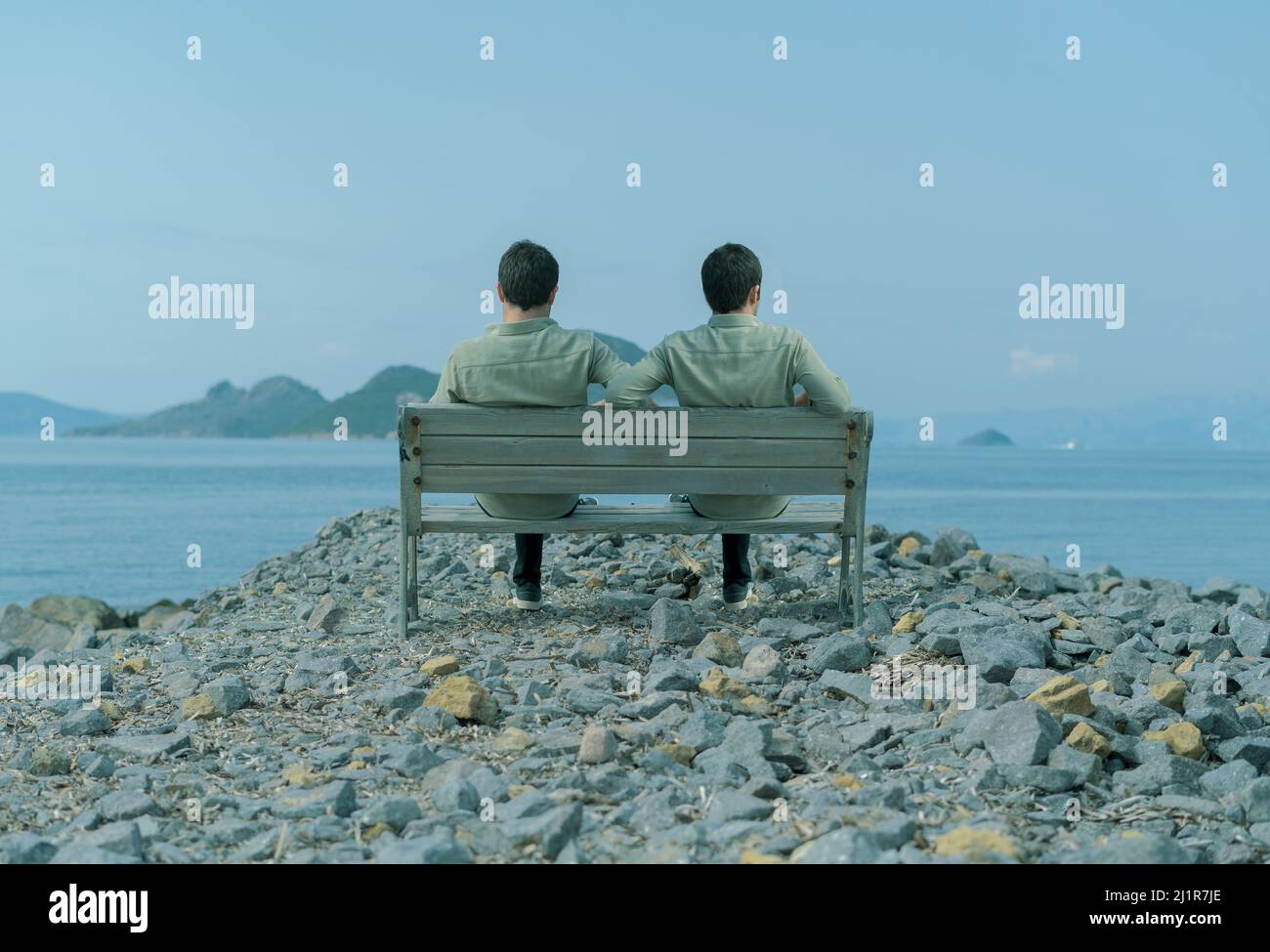 Homme solitaire assis sur une rive au bord de la mer et parlant à lui ...