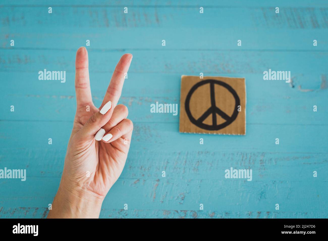 Main Making Peace signe à côté de l'icône de la paix sur un morceau de ...
