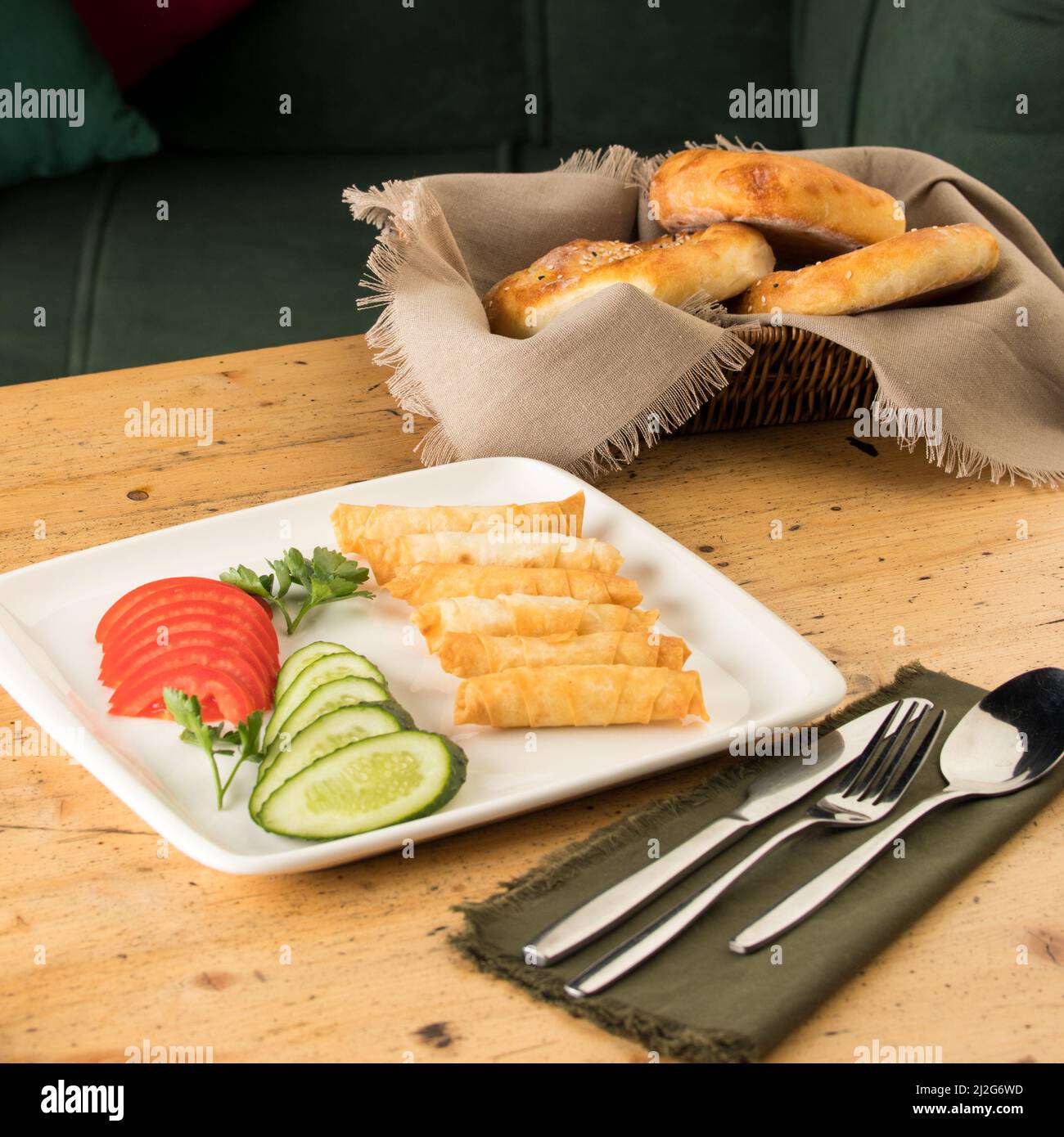 Une assiette blanche avec tomates, concombres et petits pains ...