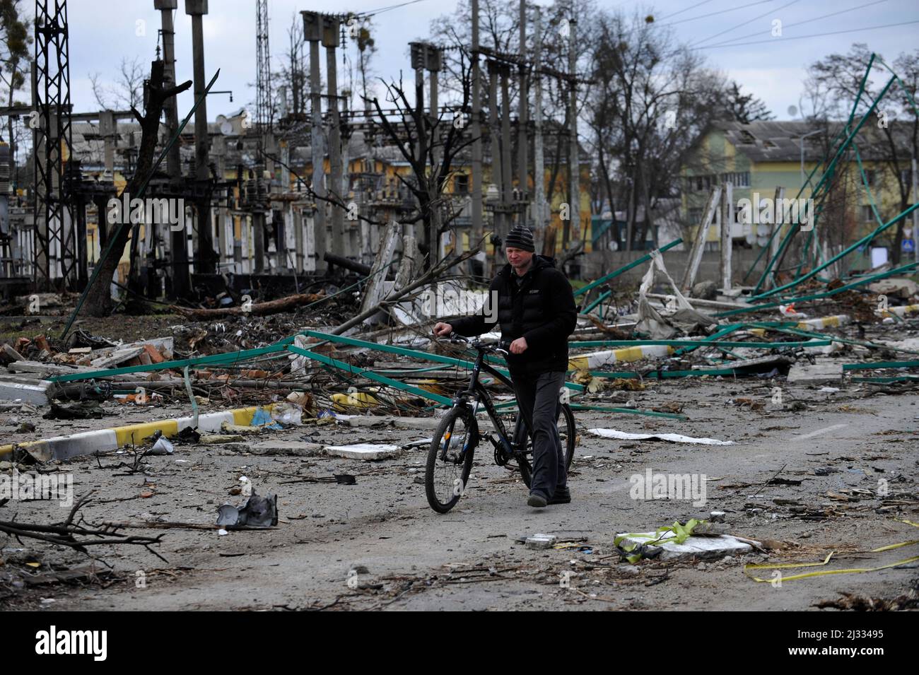 Un homme marche dans la rue avec la toile de fond de la destruction ...