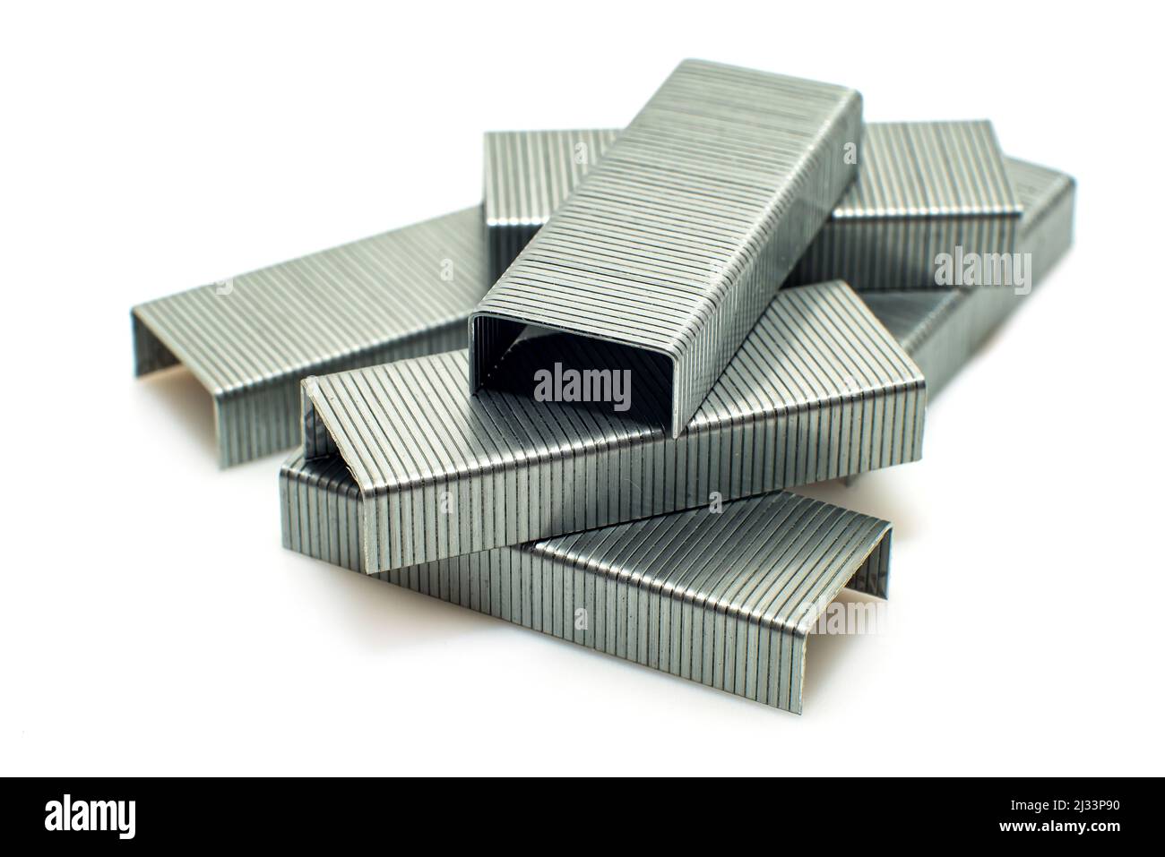 Agrafe à partir d'une agrafeuse sur fond blanc. Isoler un tas d'agrafes ...