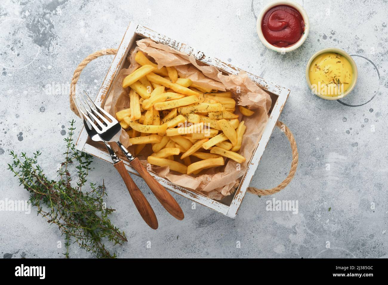 Frites. Assiette de frites savoureuses sur papier parchemin sur planche ...