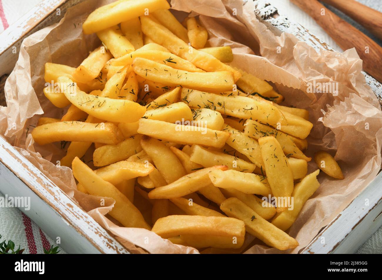 Frites. Assiette de frites savoureuses sur papier parchemin sur planche ...