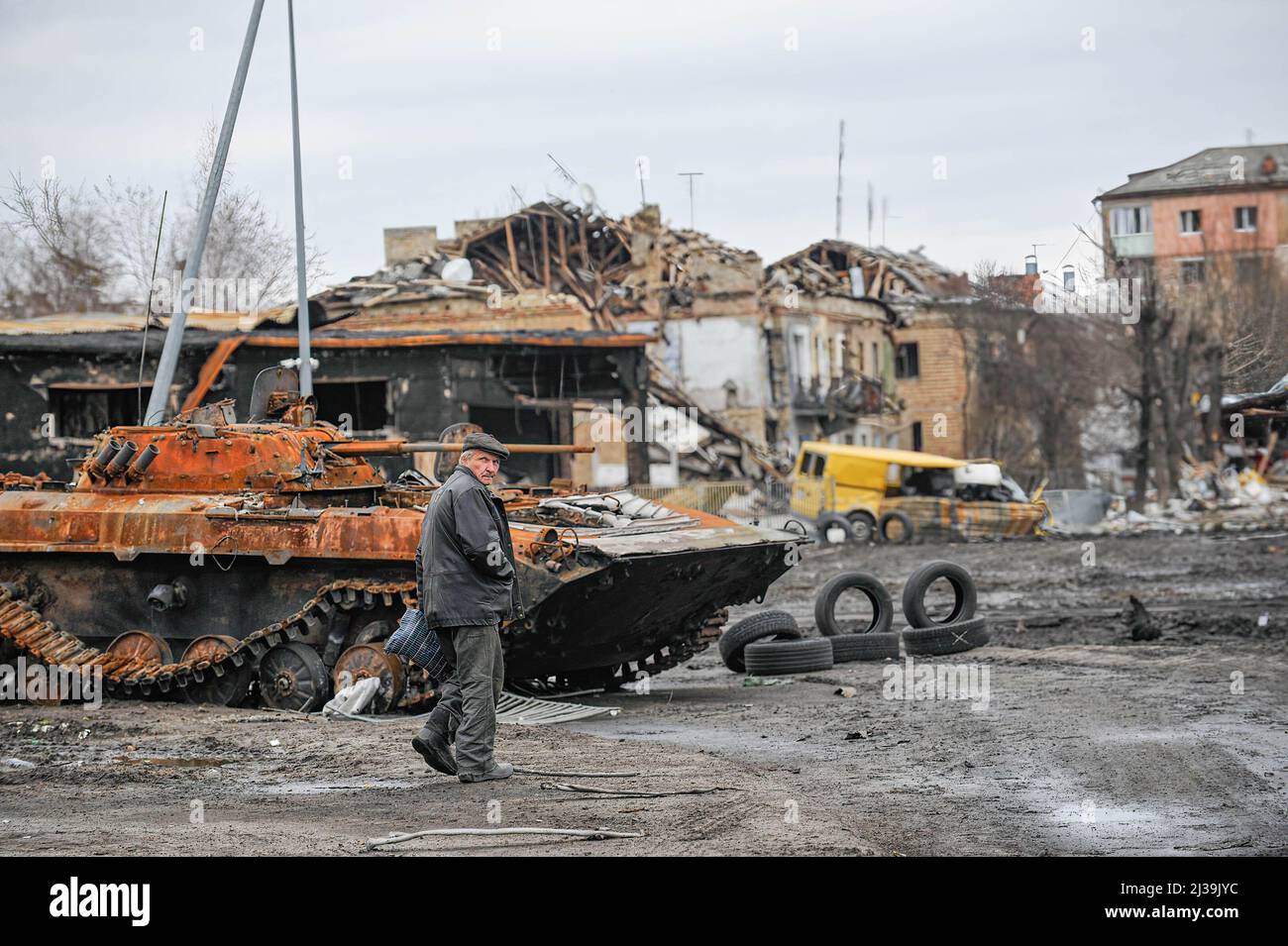 Un homme marche dans la rue avec la toile de fond de la destruction ...