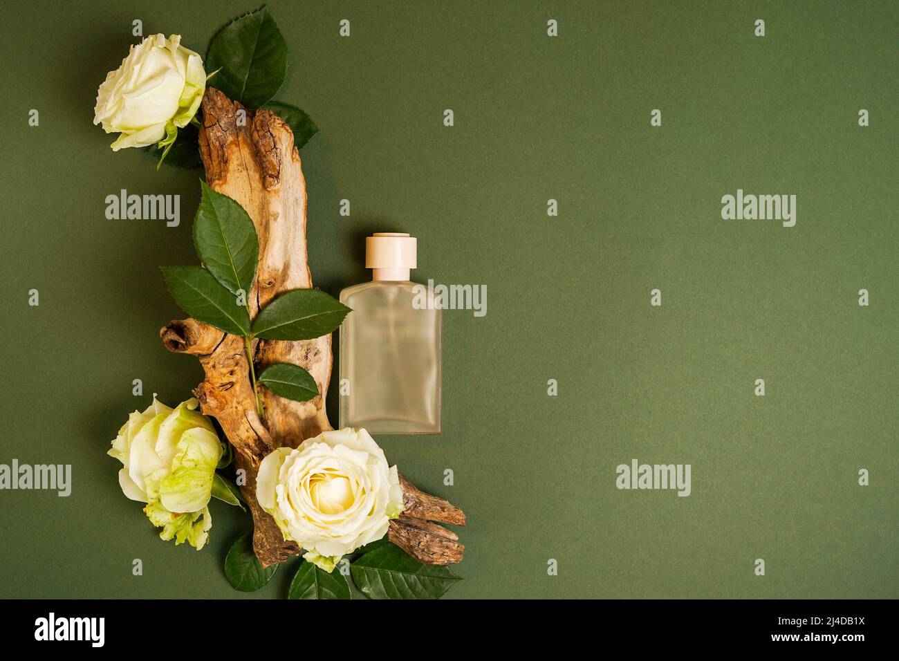 Parfum sur écorce d'arbre avec fleurs roses sur fond vert avec espace de copie. Concept de ...