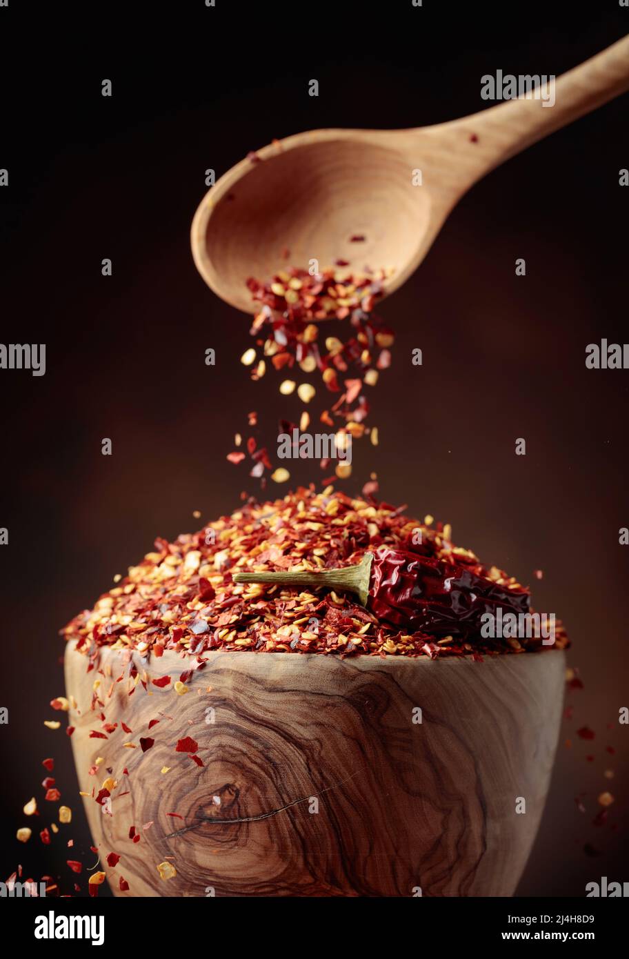 Les flocons de piment sont versés dans un plat en bois. Flocons de ...