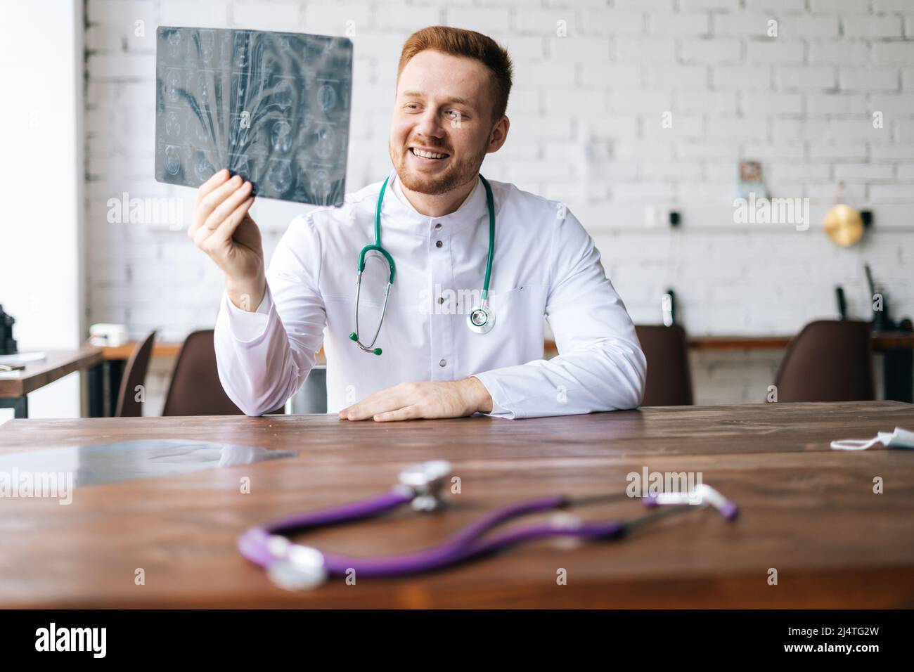 Portrait d'un homme gai en uniforme blanc examinant le cerveau scanner ...