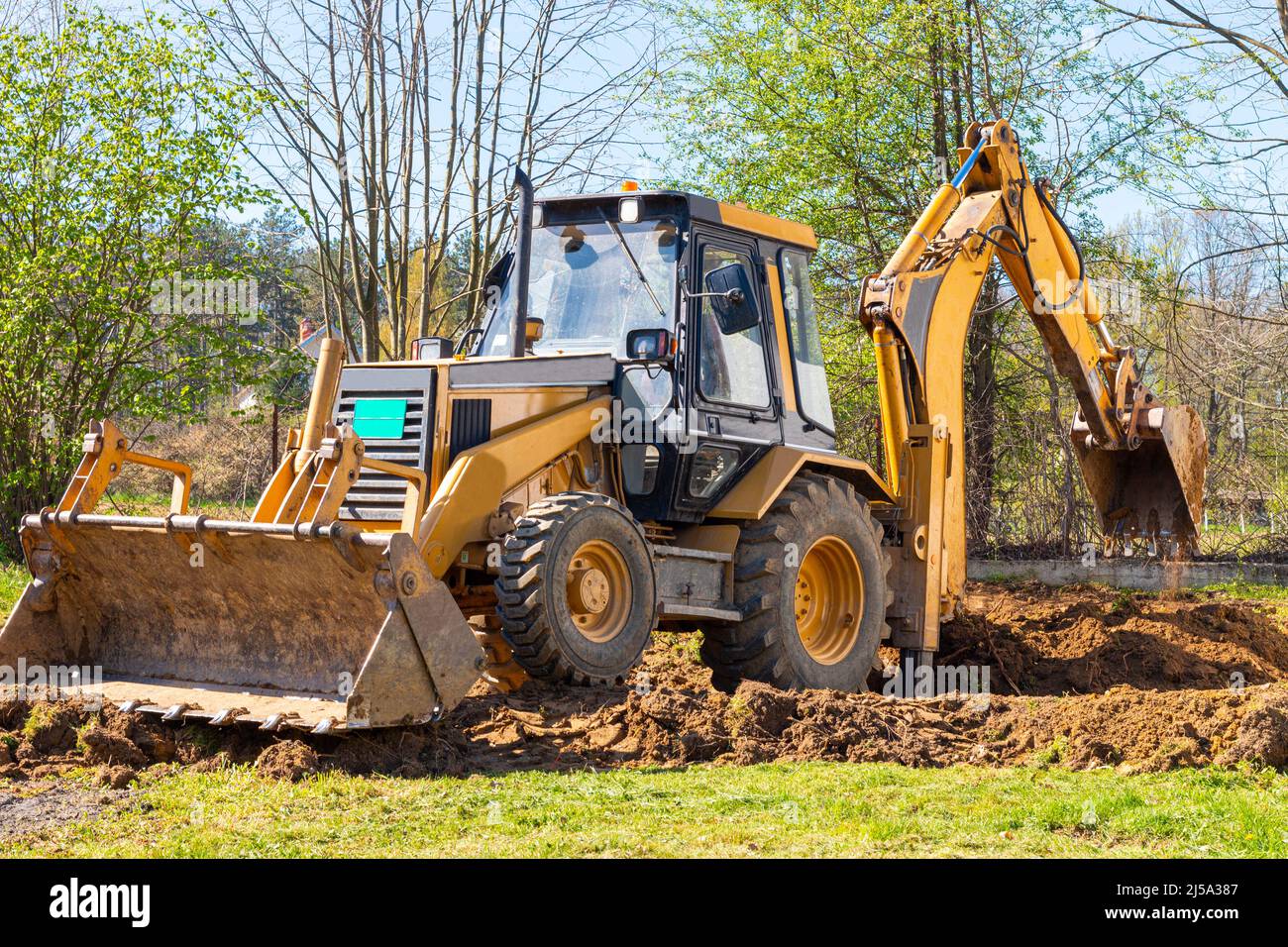 Une pelle hydraulique à godets dans le village pave la voie, creuse le ...