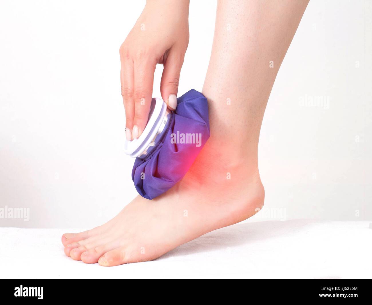 Une fille applique un bloc de glace bleu médical à l'articulation de la ...