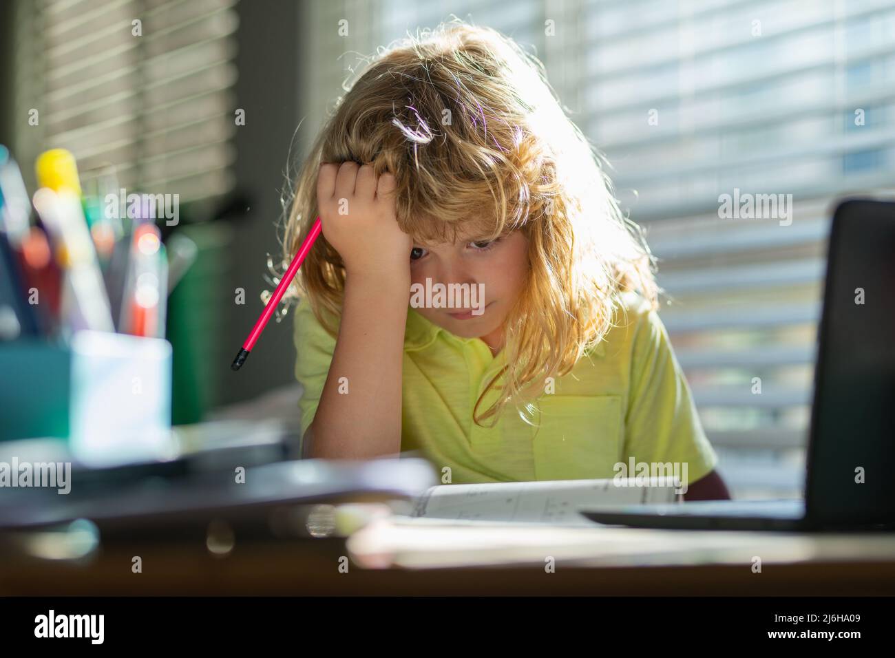 Un écolier fatigué en train de faire ses devoirs. Écriture enfant ...