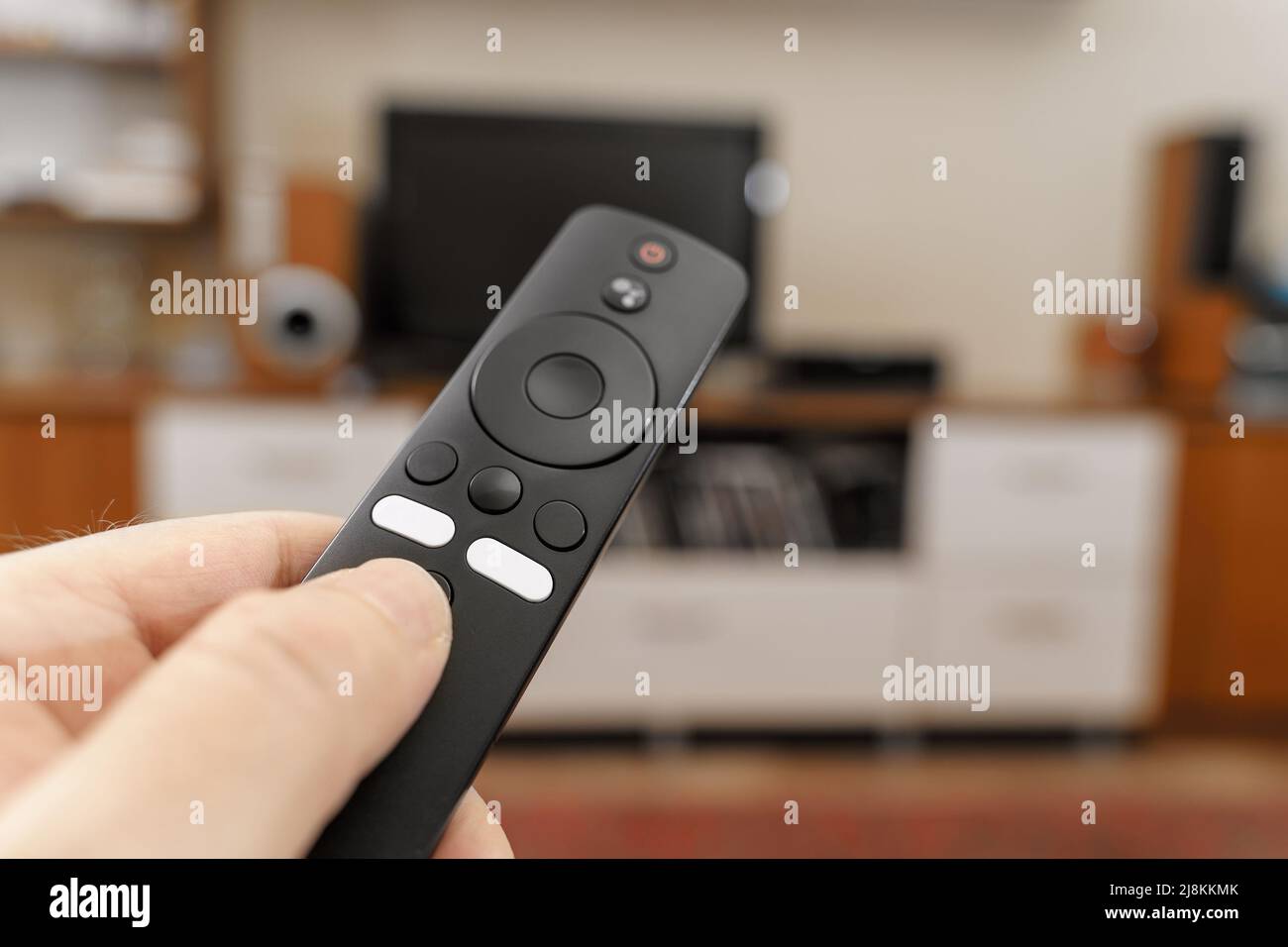 Télécommande TV à portée de main sur un fond flou TV dans un ...
