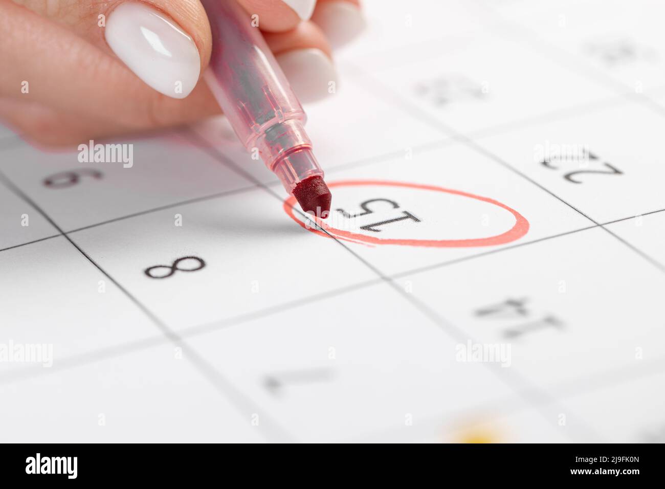 les marques de main féminine avec un marqueur rouge dans le calendrier ...