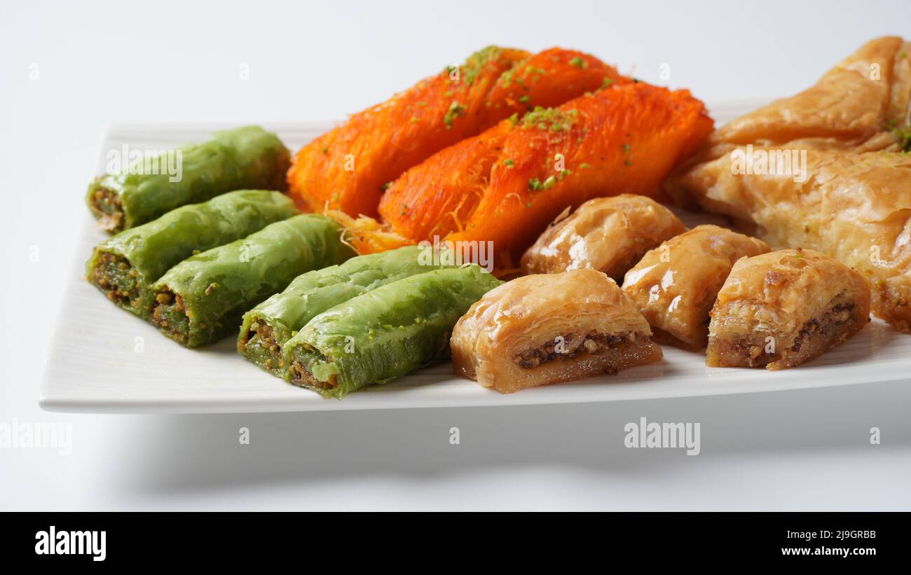 Un plateau de pâtisseries turques comprenant du baklava, du knafeh ...