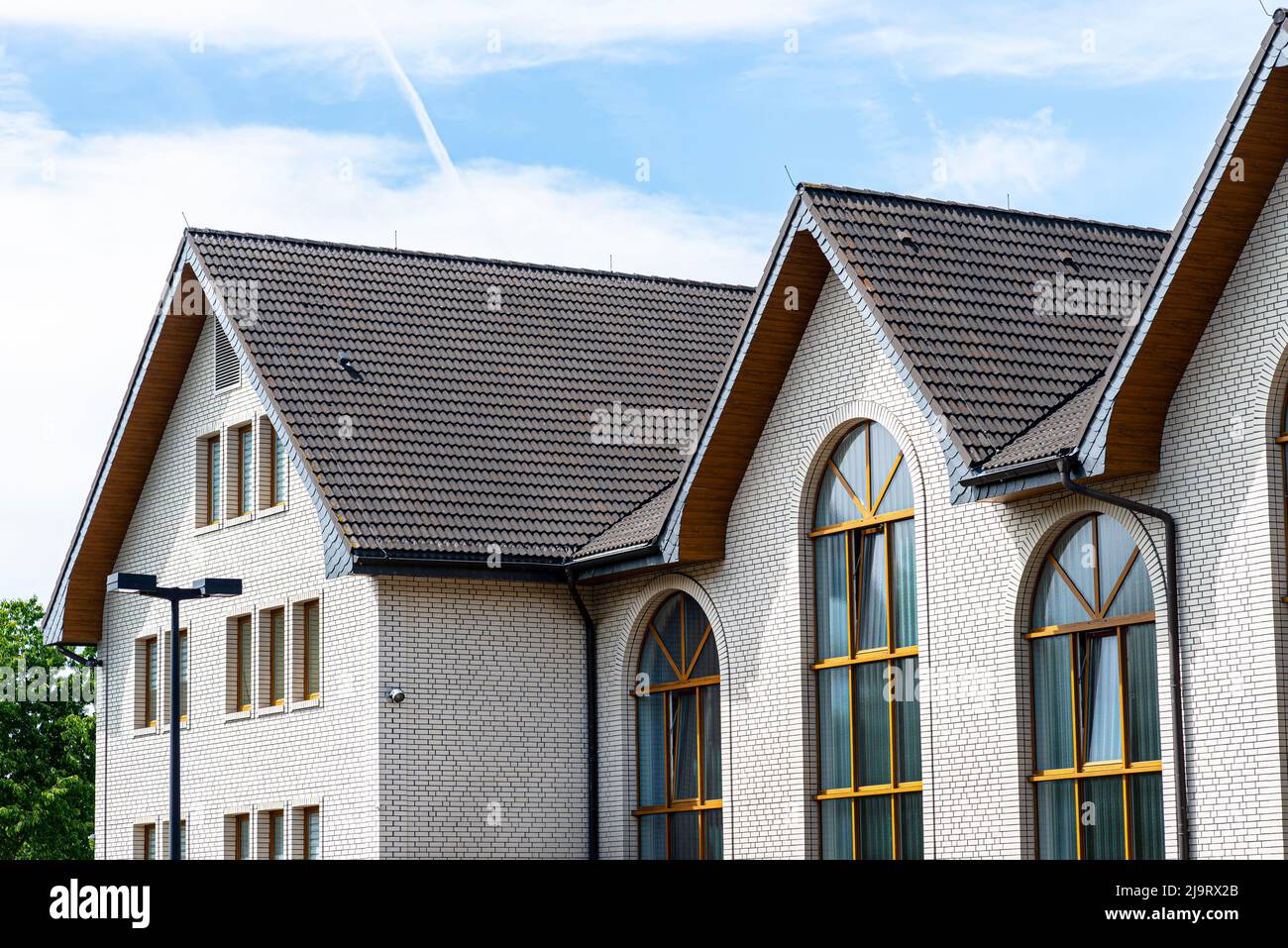 L'église a une façade classique en brique blanche et un toit conique ...