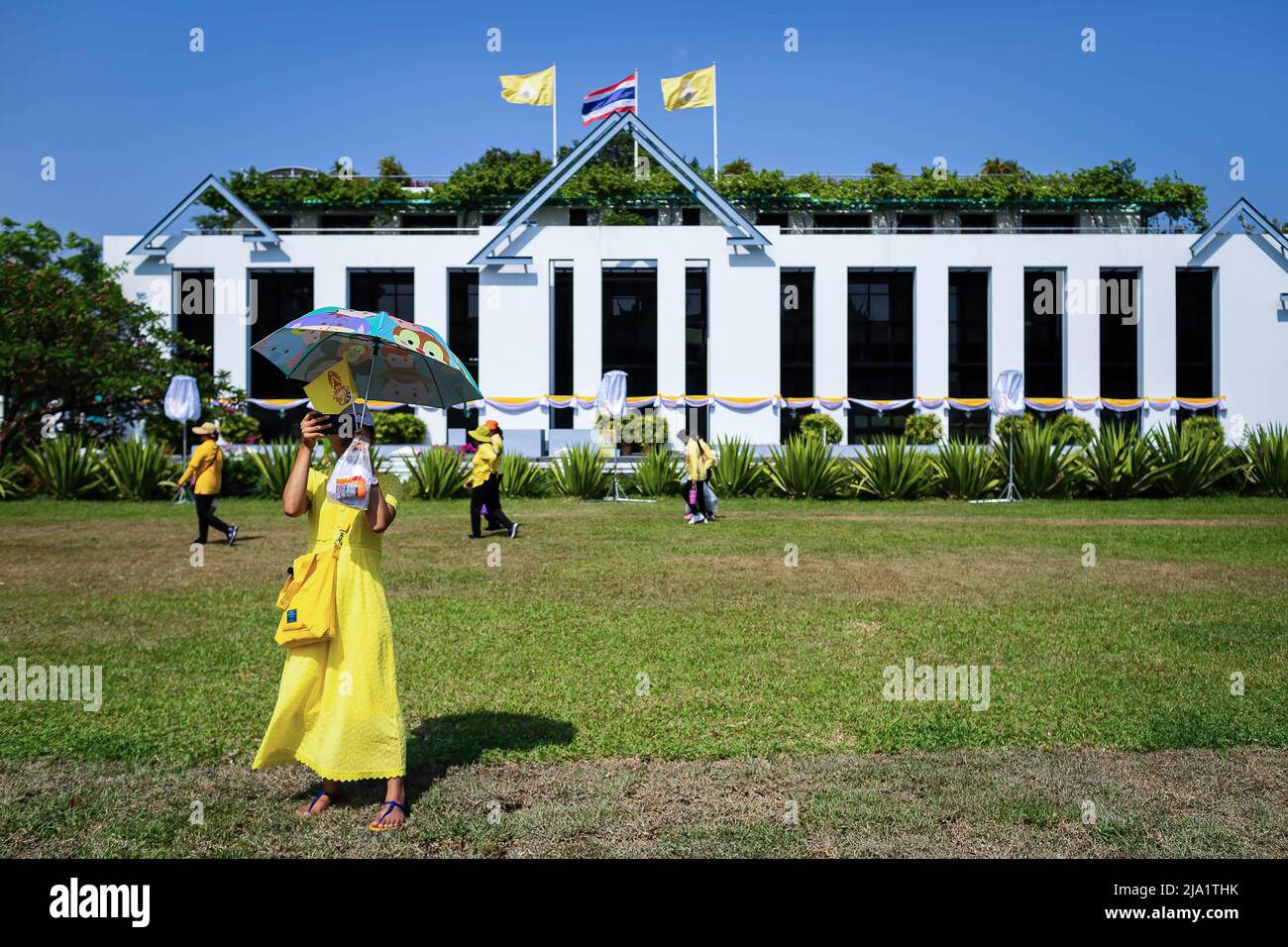 Une femme en tissu jaune pose pour une photo en attendant la procession ...