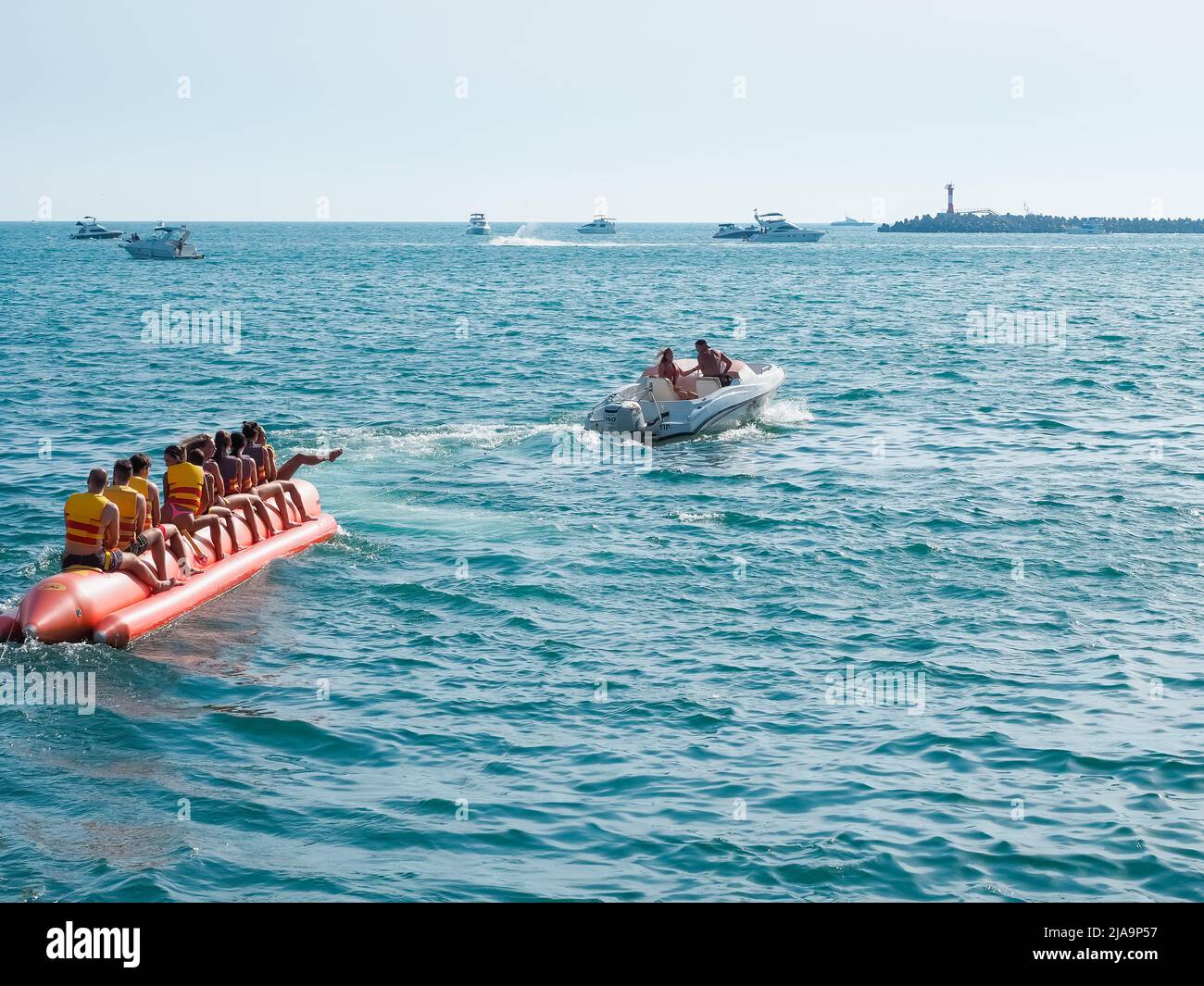 Un groupe de personnes à bord d'une banane gonflable attachée à un ...