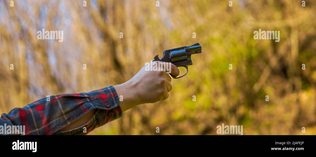 Homme méconnaissable avec revolver visant la cible sur la portée de tir ...