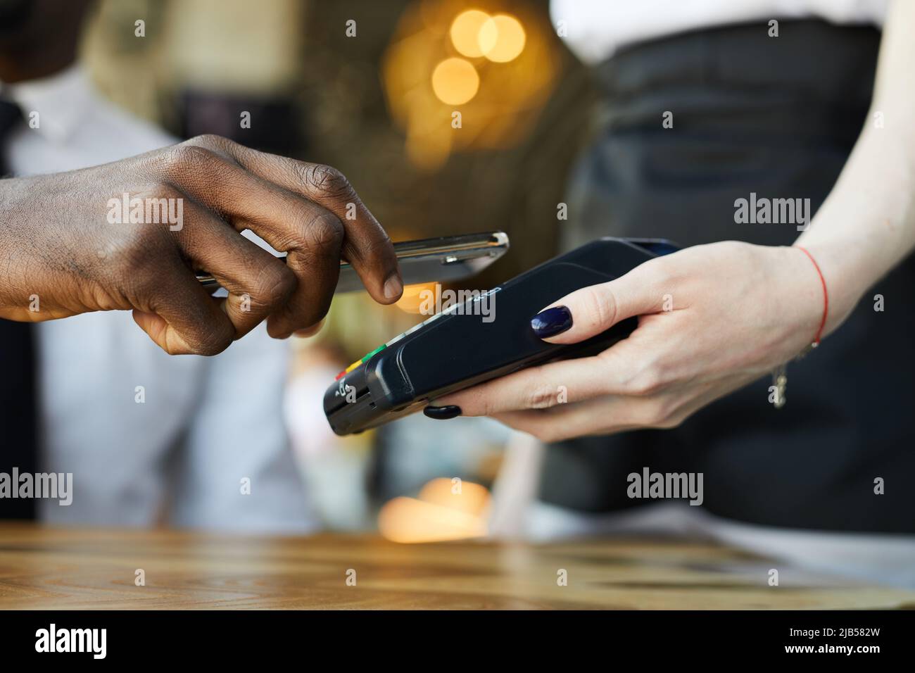 Gros plan d'un client noir méconnaissable payant sa facture via une ...