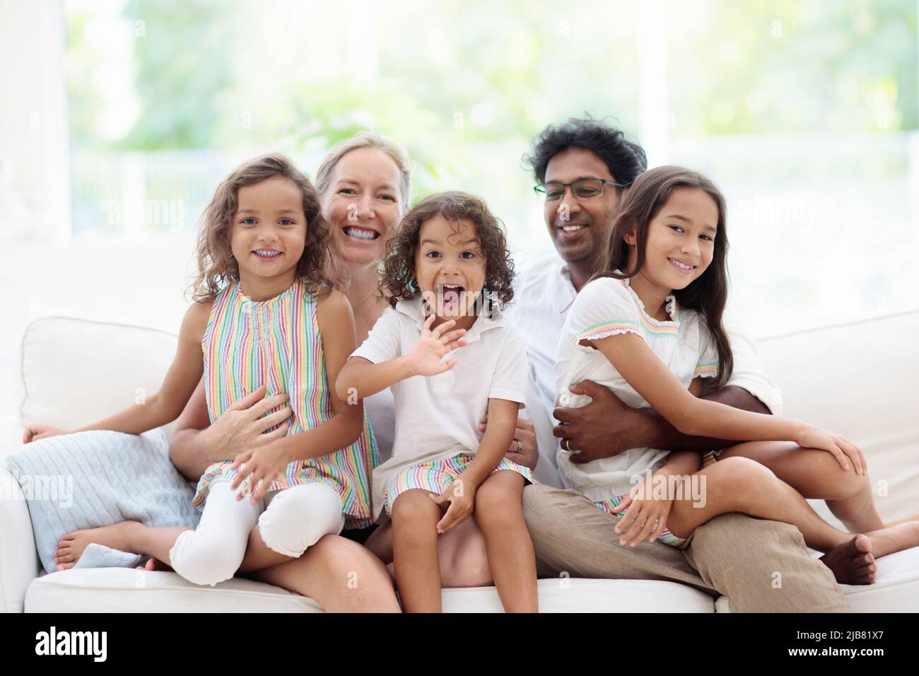Bonne famille avec les enfants à la maison. Parents et enfants assis ...