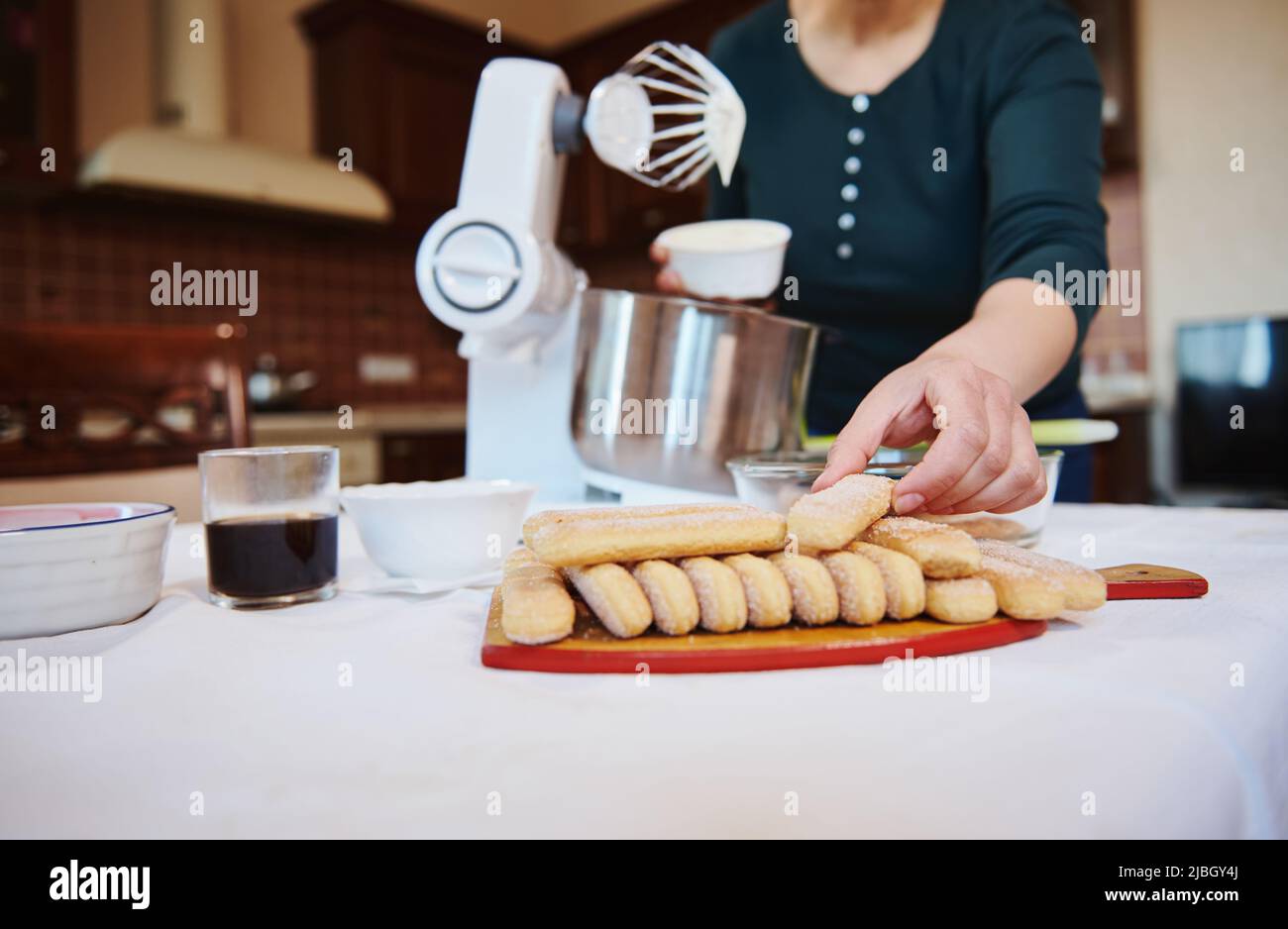 Détails d'une femme mains tenant des biscuits éponge ladyfingers tout ...