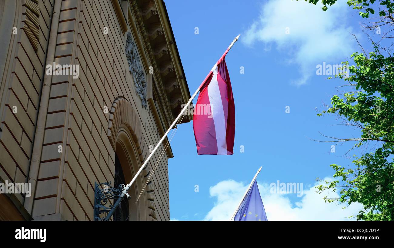 Le symbole officiel de la Lettonie est un drapeau avec deux rouges et ...