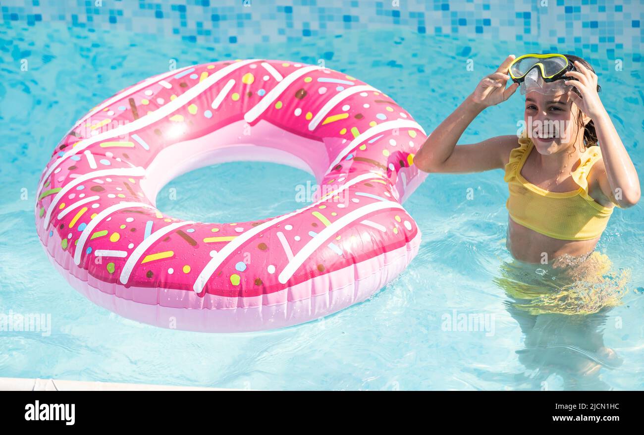 Jolie petite fille dans un maillot de bain allongé sur un cercle ...