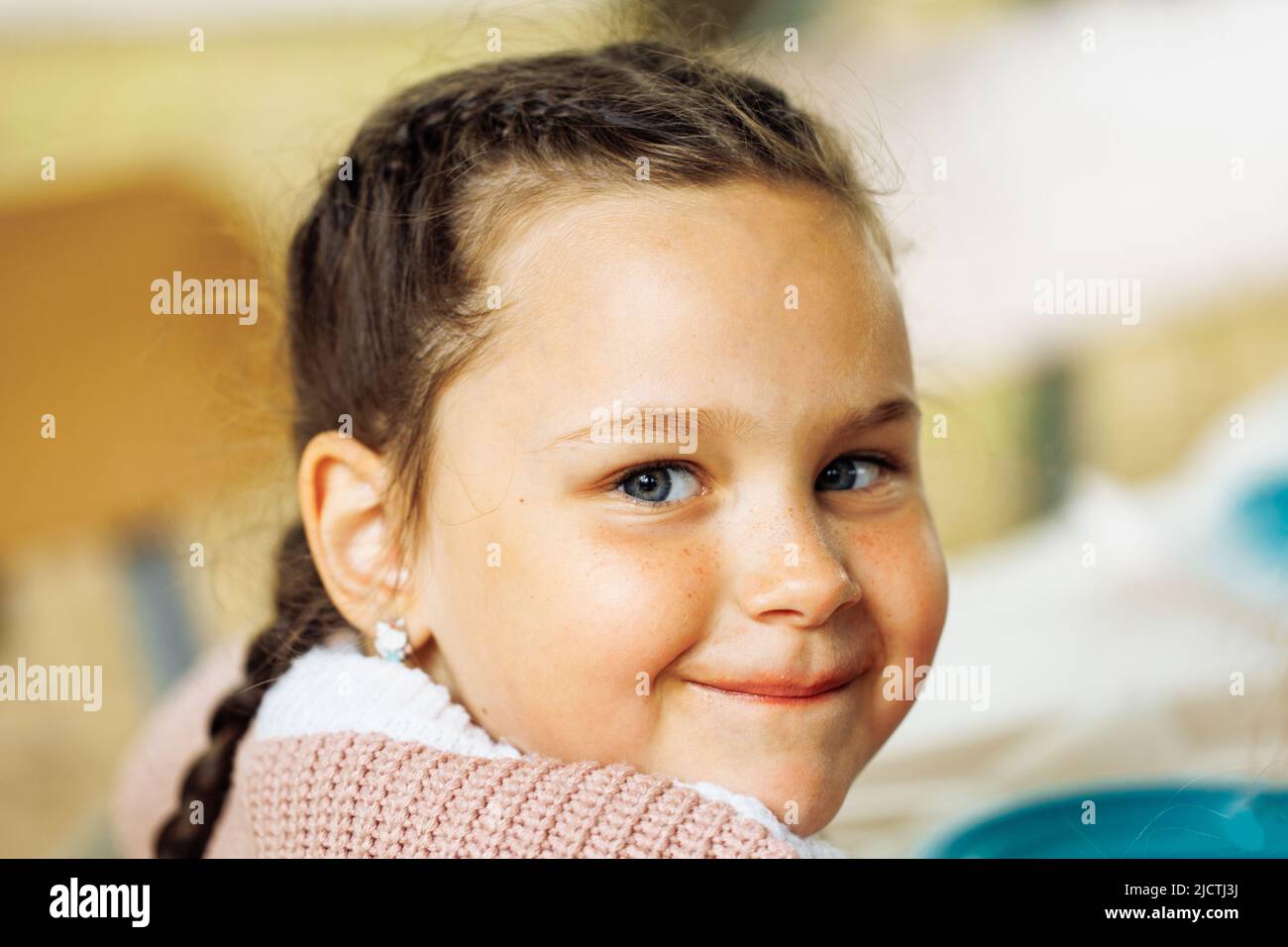 Portrait en gros plan d'une petite fille souriante avec de beaux yeux ...