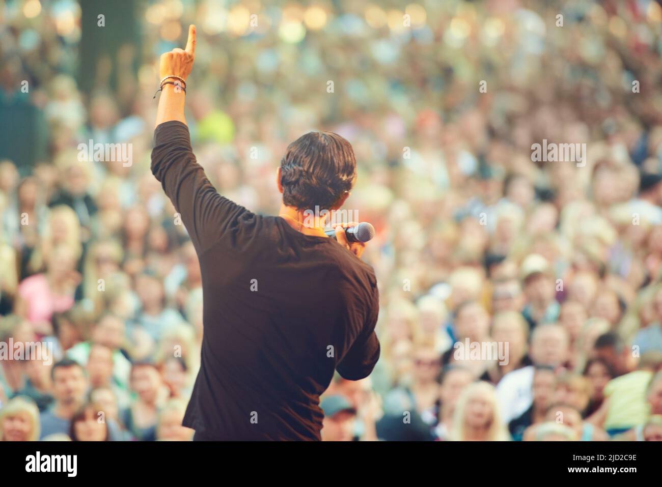La foule l'aime. Un chanteur se présentant devant une foule massive ...