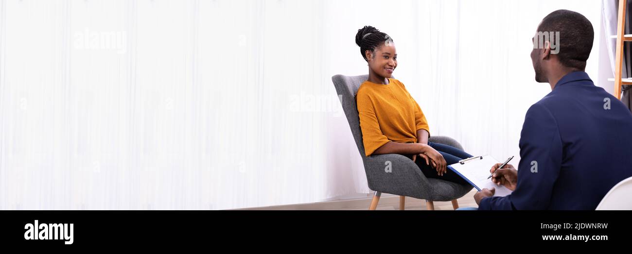 Jeune femme africaine assis près de psychologue avec presse-papiers ...