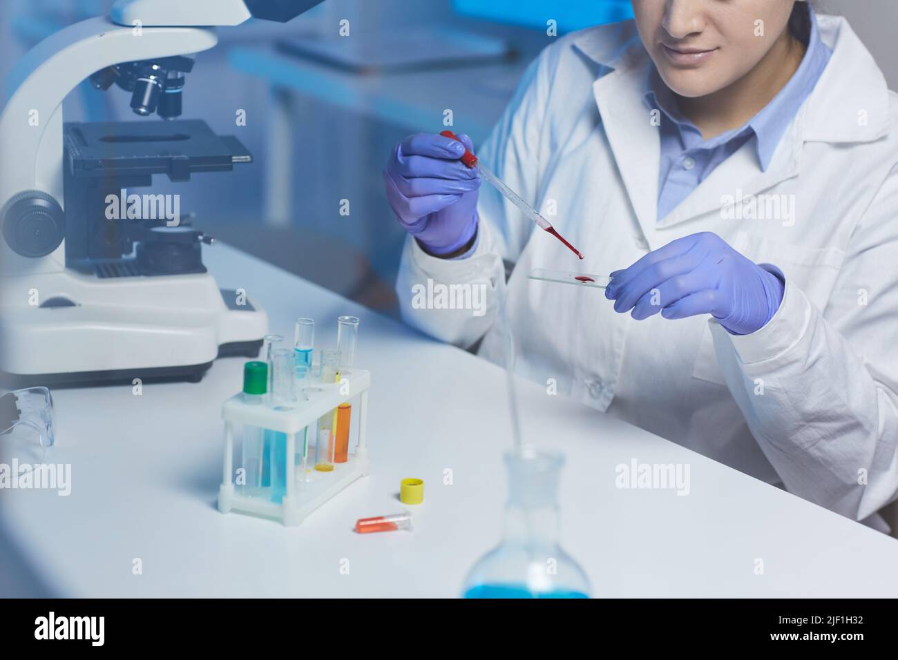 Un chercheur de laboratoire très actif en blouse blanche et gants en ...