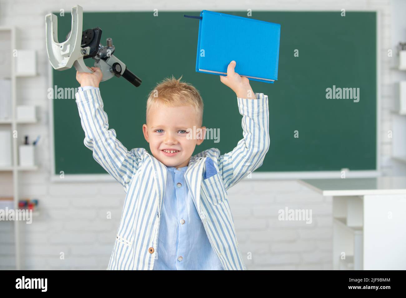 Étonnant garçon d'école avec microscope et livre. Succès, motivation ...