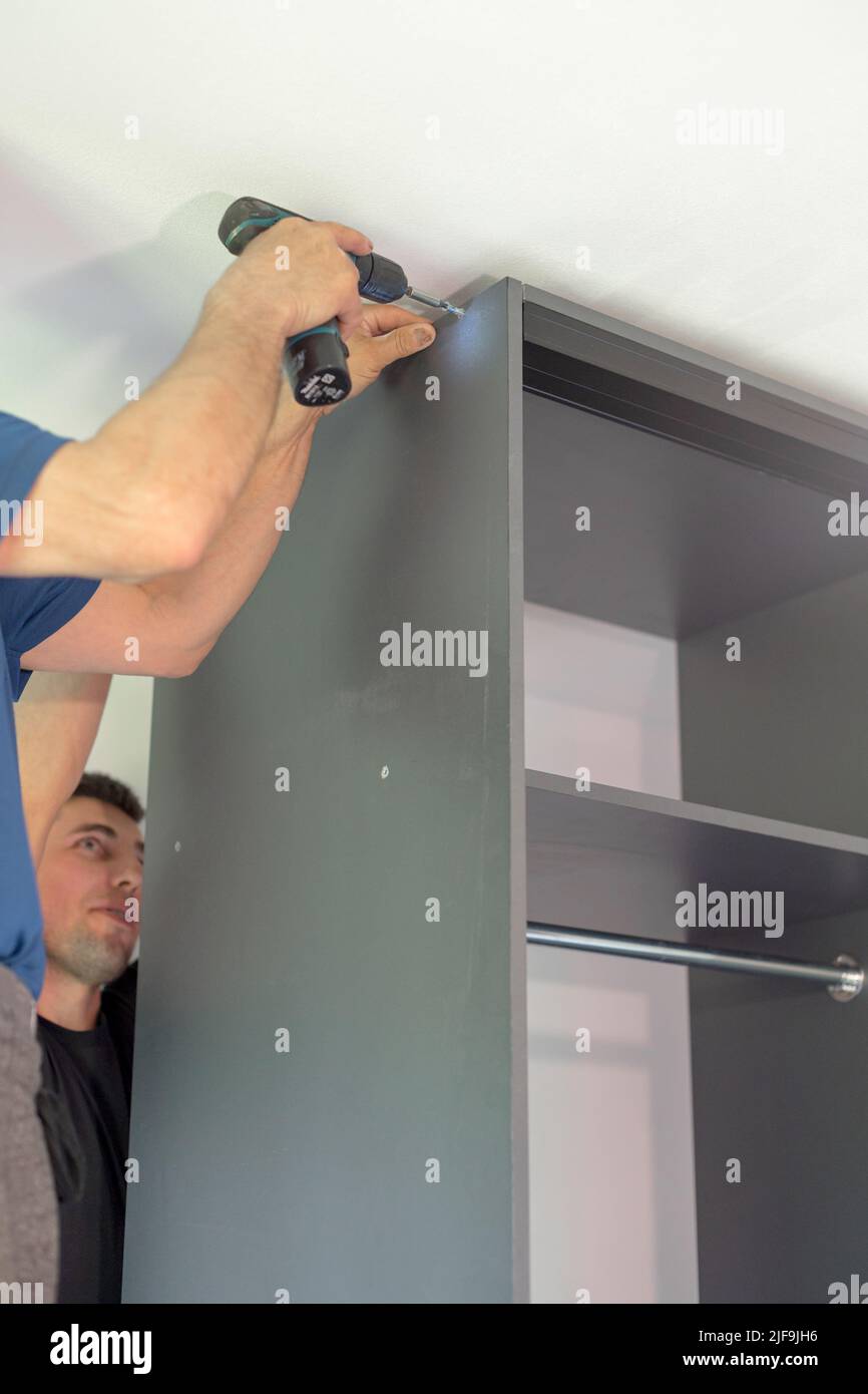 Le processus de vissage de la vis, l'installation d'une armoire de ...