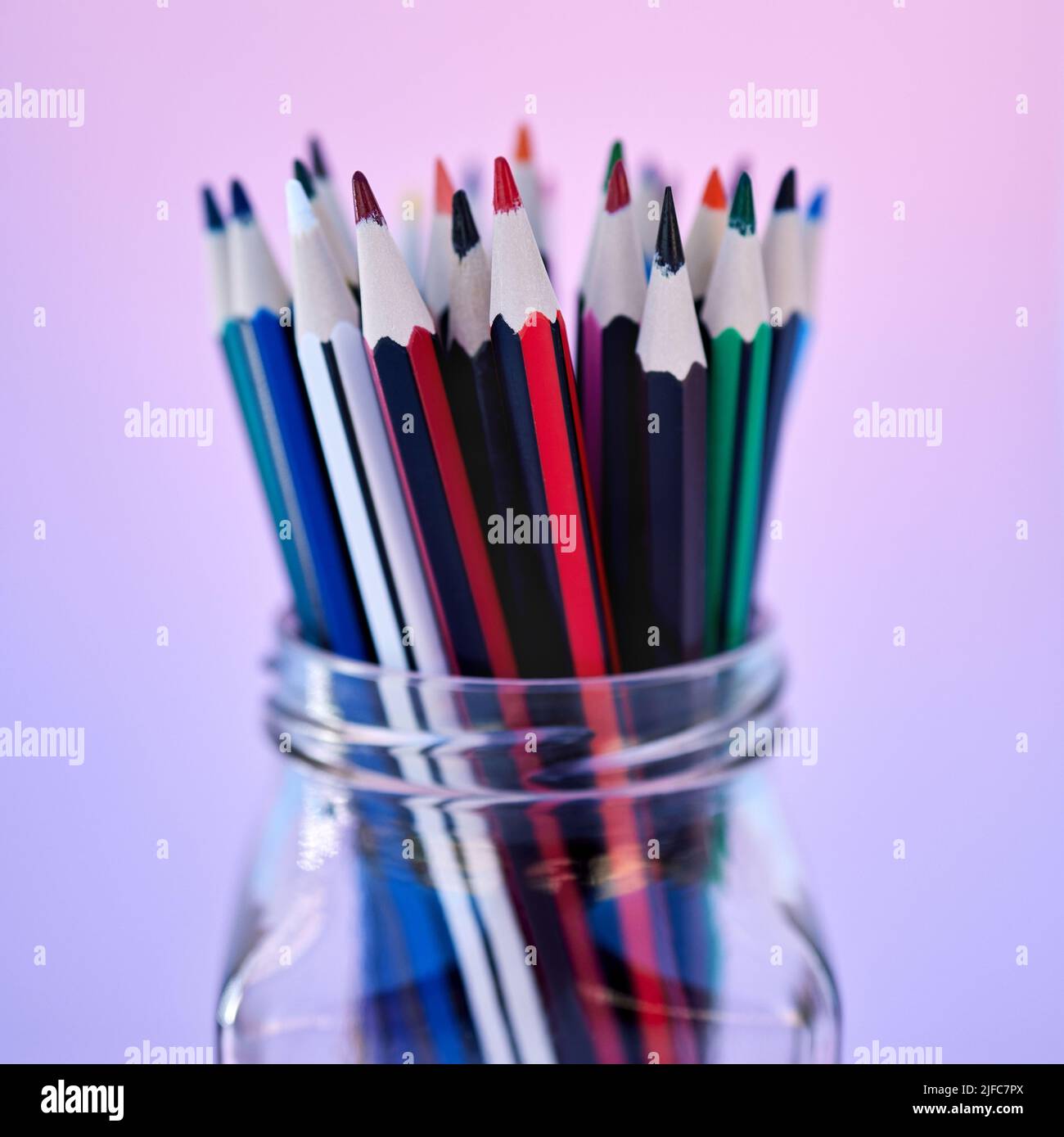 Gros plan de nombreux crayons dans un pot en verre isolé sur un fond ... Gros plan de nombreux crayons dans un pot en verre isolé sur un fond ...