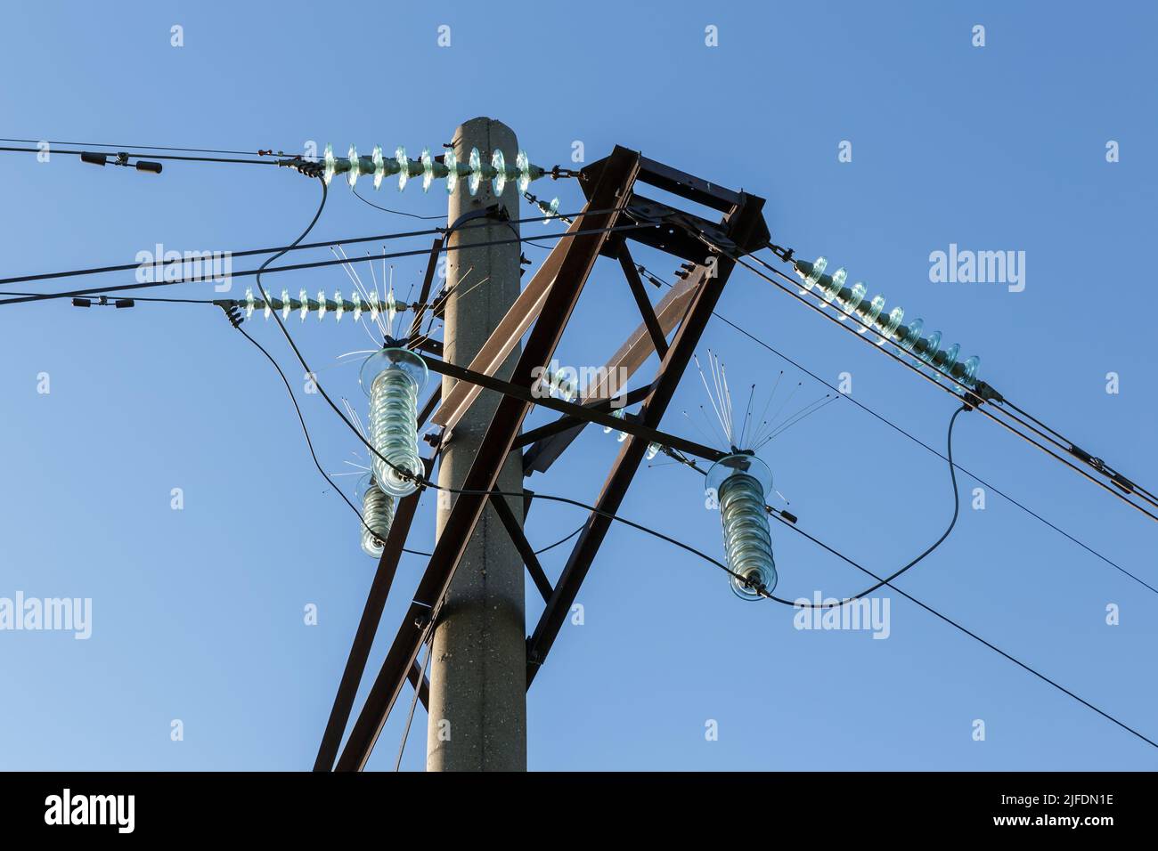 Pylône électrique en béton avec isolants en verre et pointes d'oiseau ...