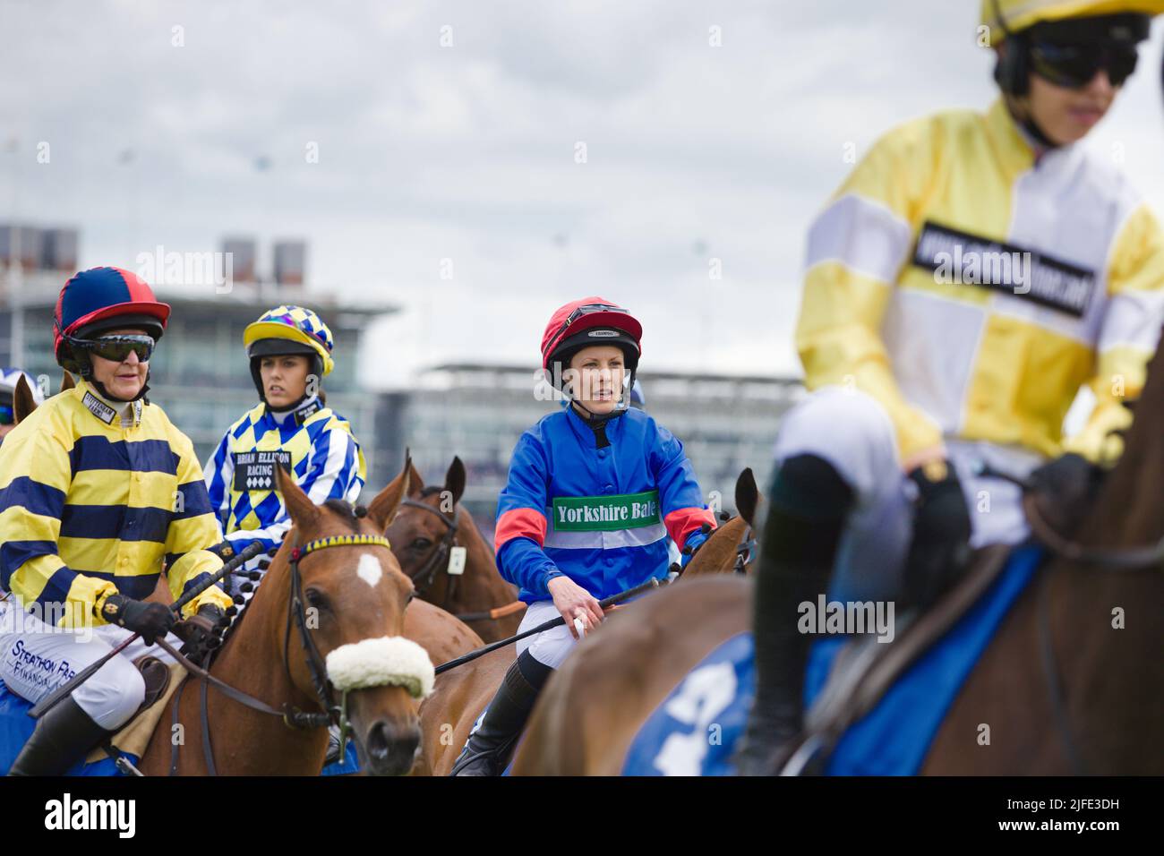 Un groupe de jockeys amateurs féminins s'alignent devant les portes de ...
