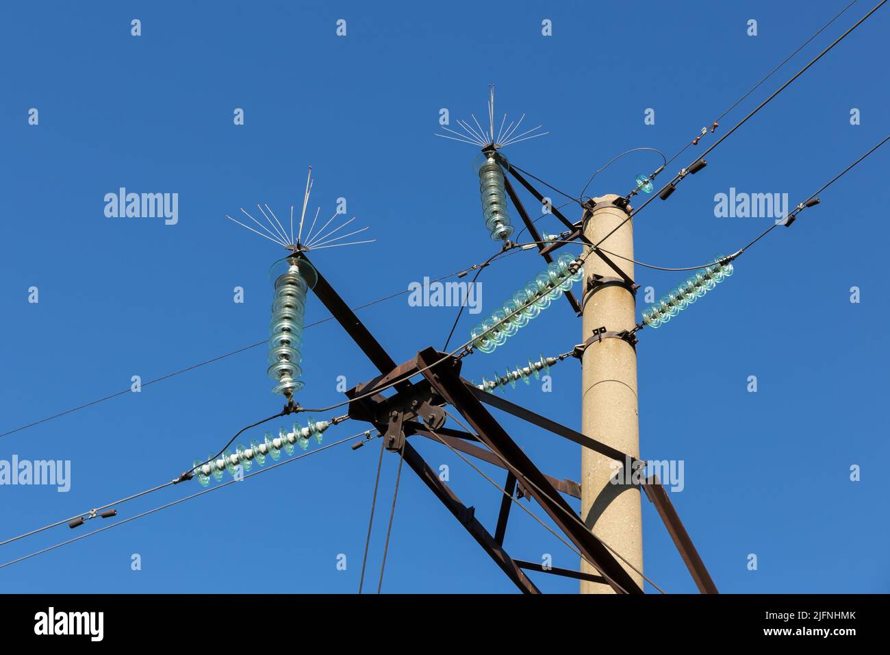 Pylône électrique en béton avec isolants en verre et pointes d'oiseau ...