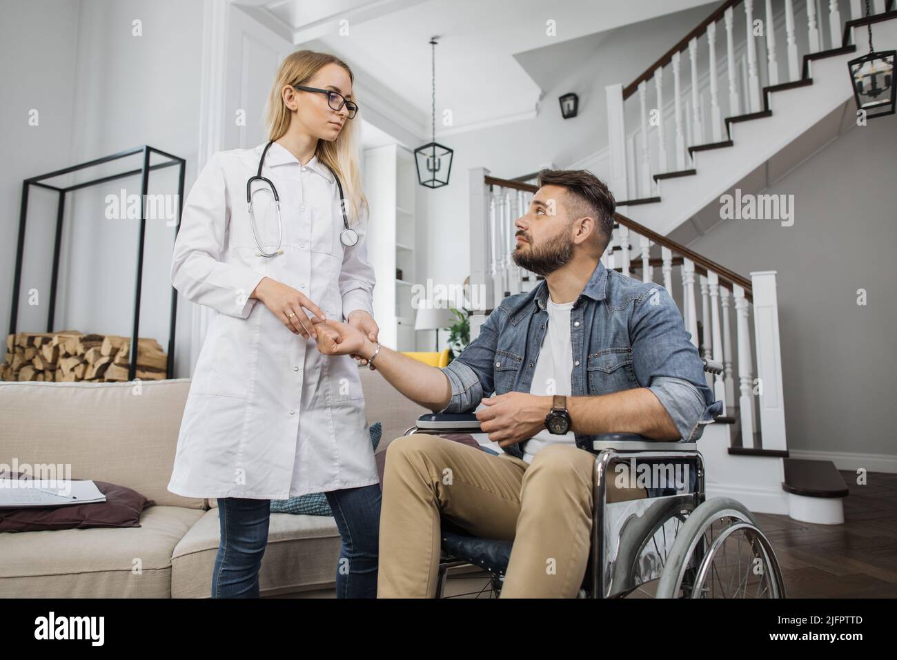 Femme médecin touchant le poignet de l'homme handicapé pour mesurer l ...