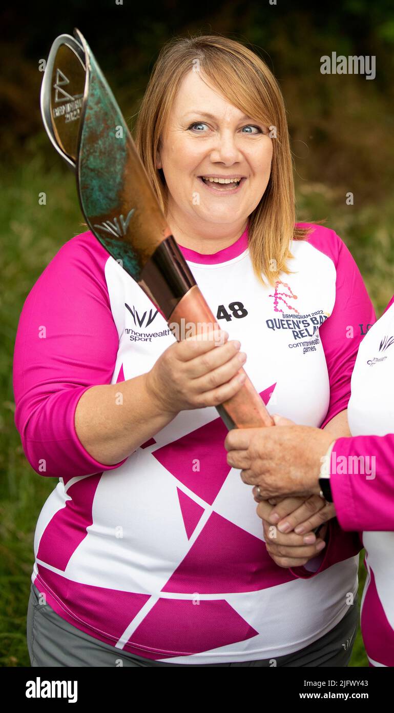 Un Beaton Bearer tient le Queen’s Baton lors d’une visite de l’équipe ...