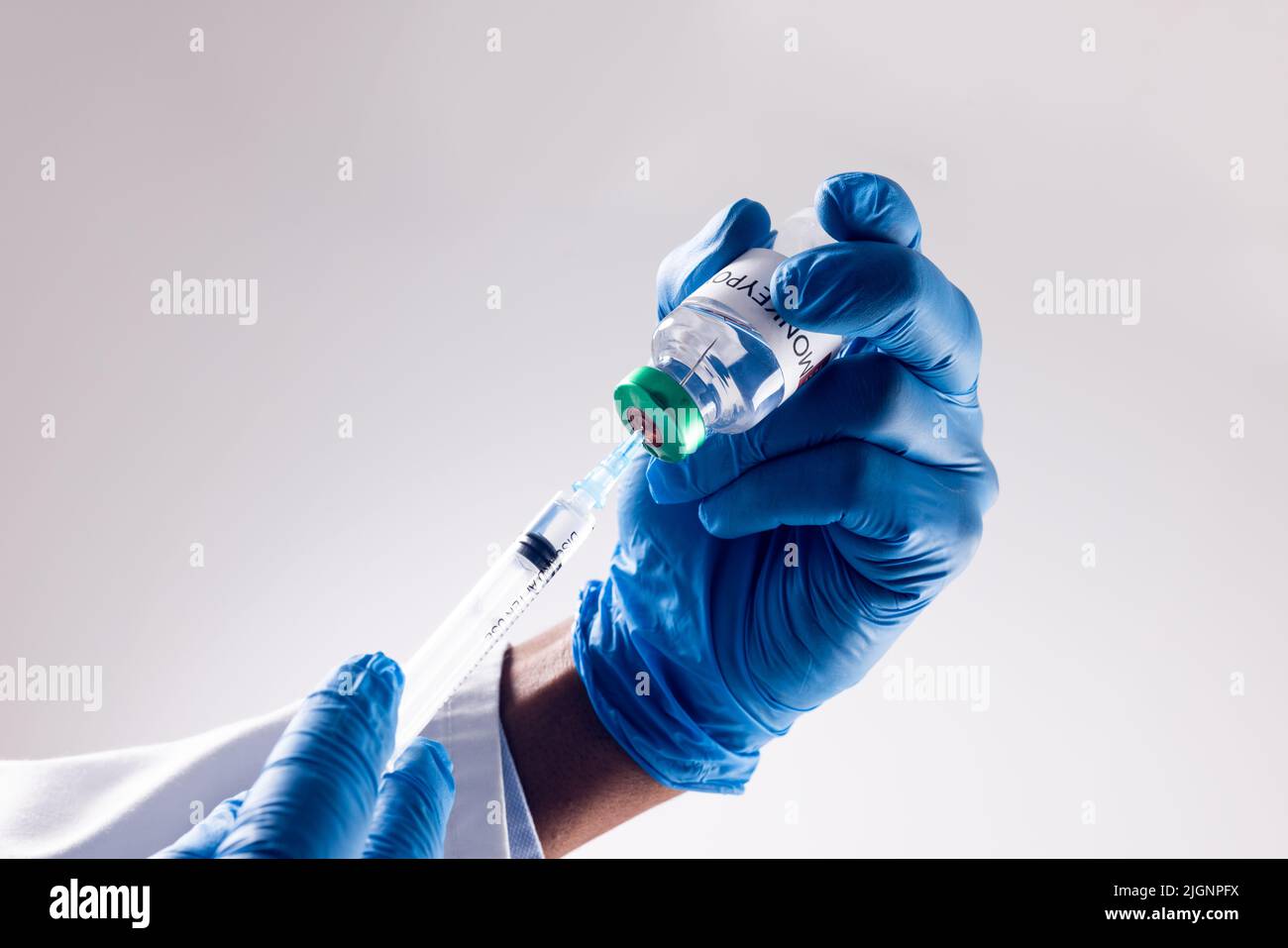 Mains du médecin tenant le flacon avec le virus de la variole du singe ...