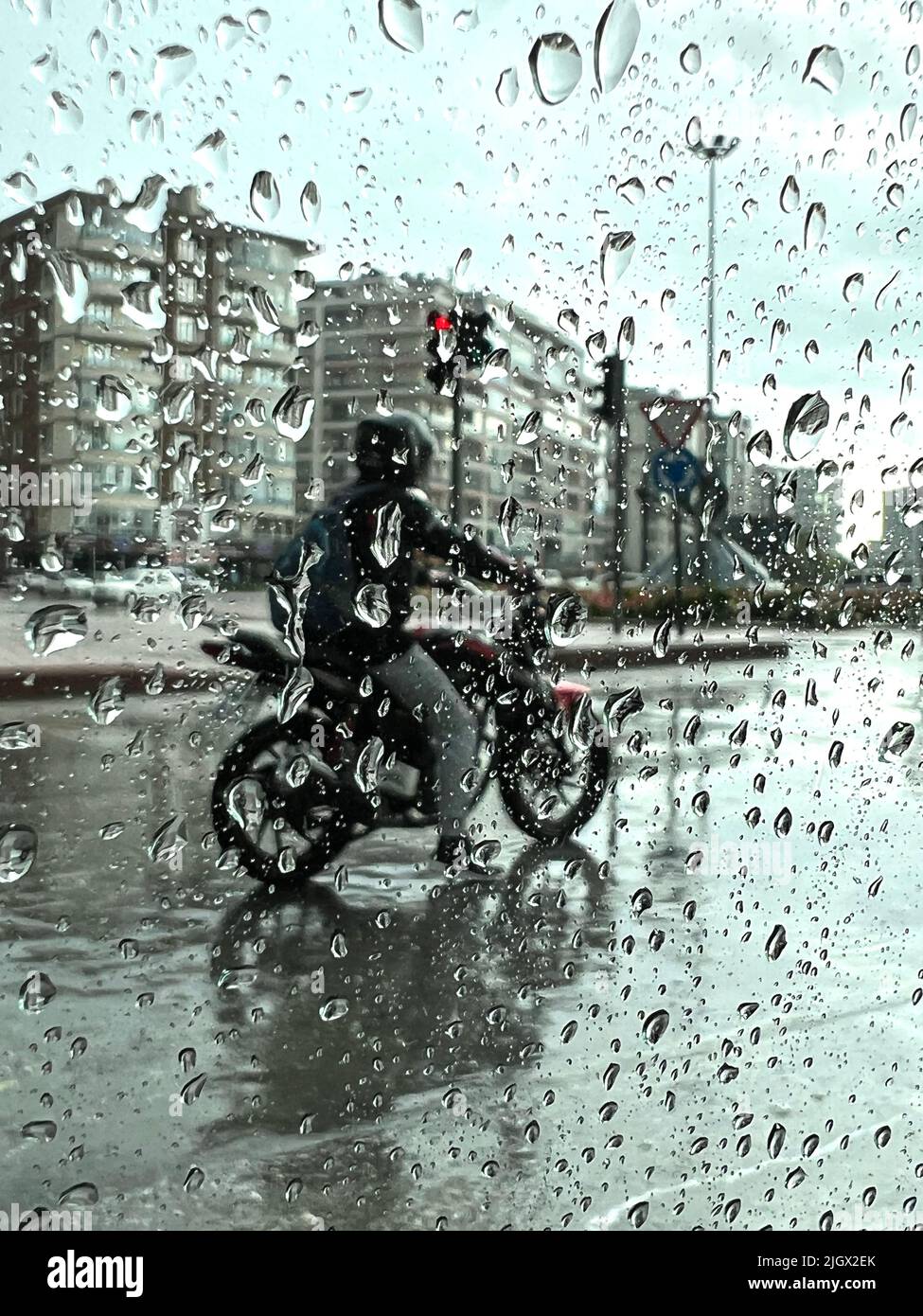 Biker sous une pluie forte, image floue et sombre ou déprimée du Biker ...
