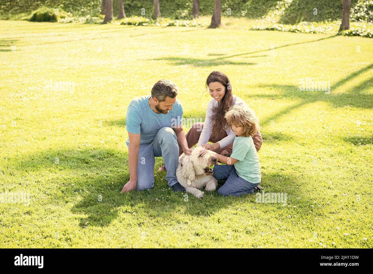 Bonne Famille De Mère Papa Et Enfant Fils Jouant Avec Chien Dans L