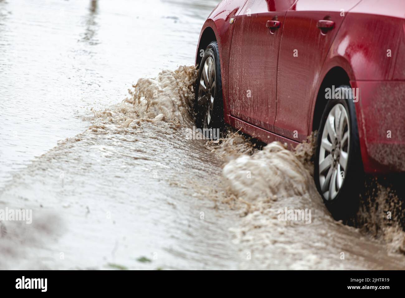 Voiture coincée dans la boue, roue de voiture dans une flaque sale ...