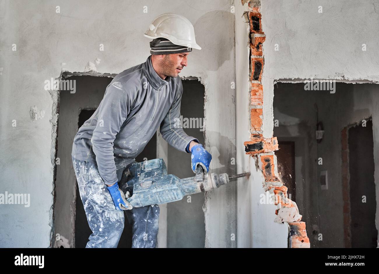 Vue latérale mâle professionnel des murs de démolition dans le casque ...