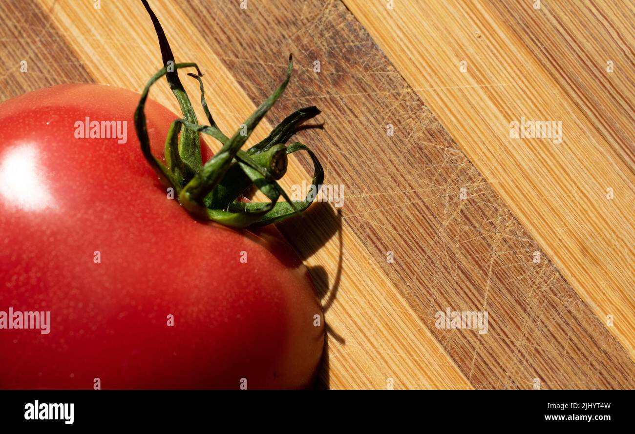 Une tomate rouge, coupée. Une demi-tomate isolée sur une planche à ...