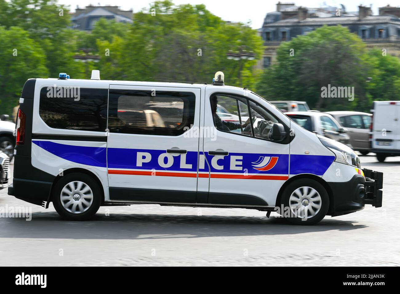 Une voiture de police (camion, fourgonnette) traverse la ville pour ...