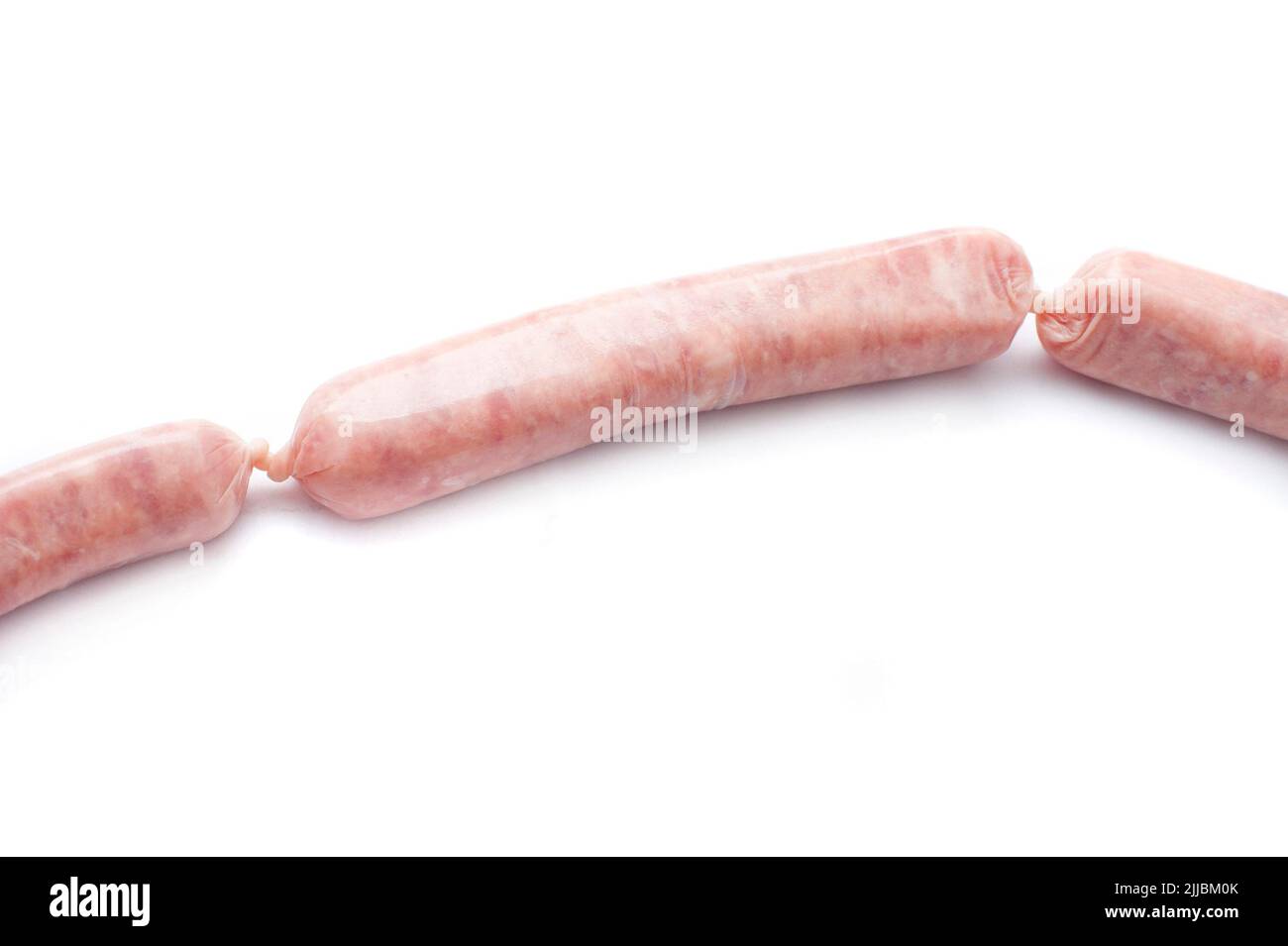 Saucisse de porc cru liée à deux saucisses supplémentaires , une de chaque côté, sur un fond ...