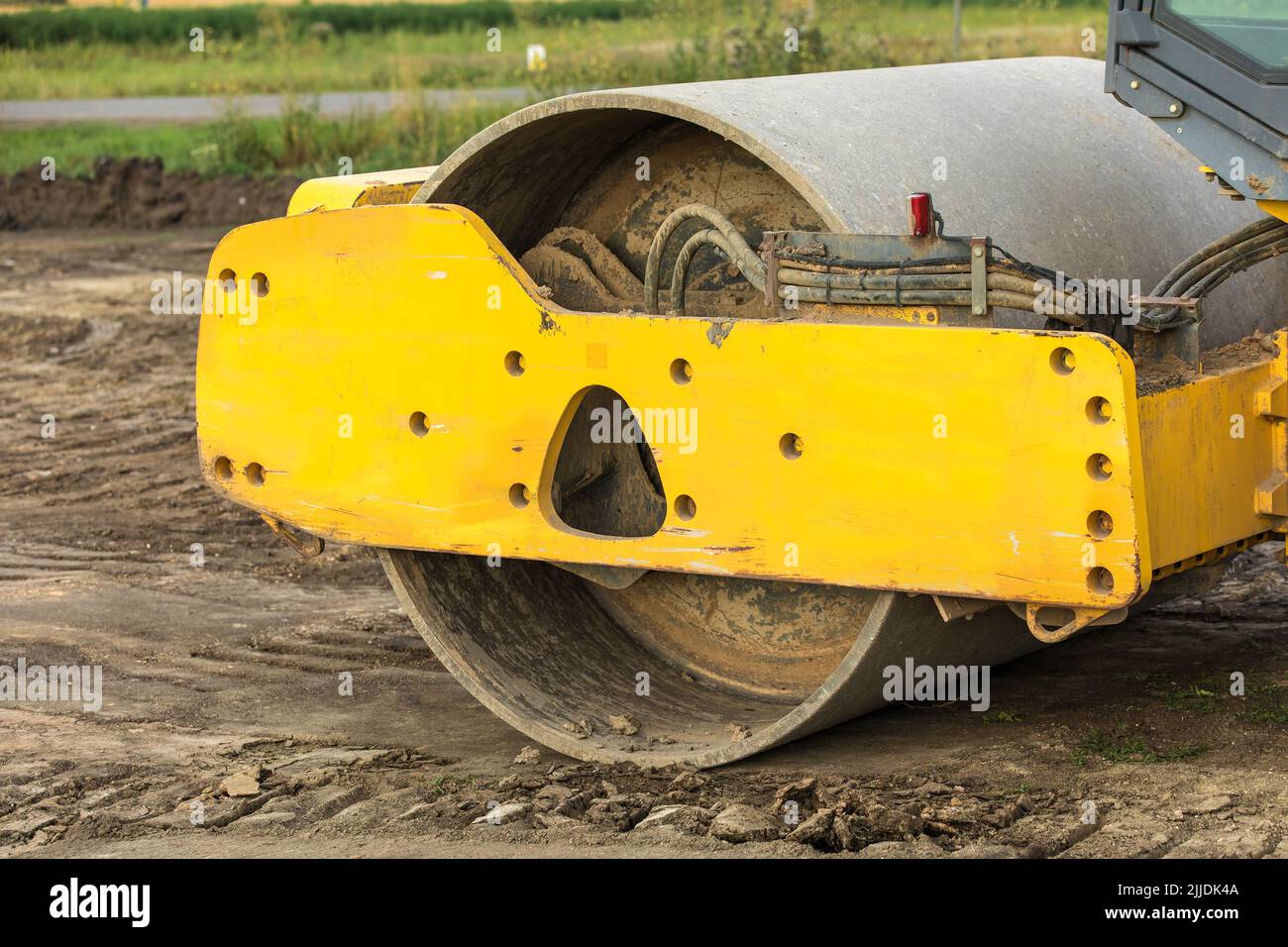 Le rouleau vibrant lourd sur la chaussée de compactage fonctionne ...